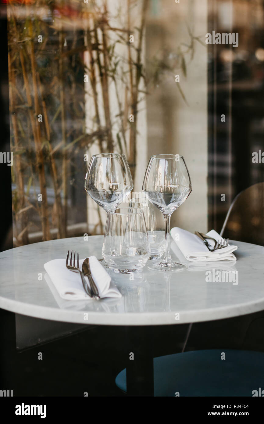 Table setting in a French restaurant for two. View through a window ...