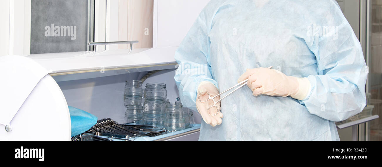Doctor's hand holding vascular clamps in the operating room ...