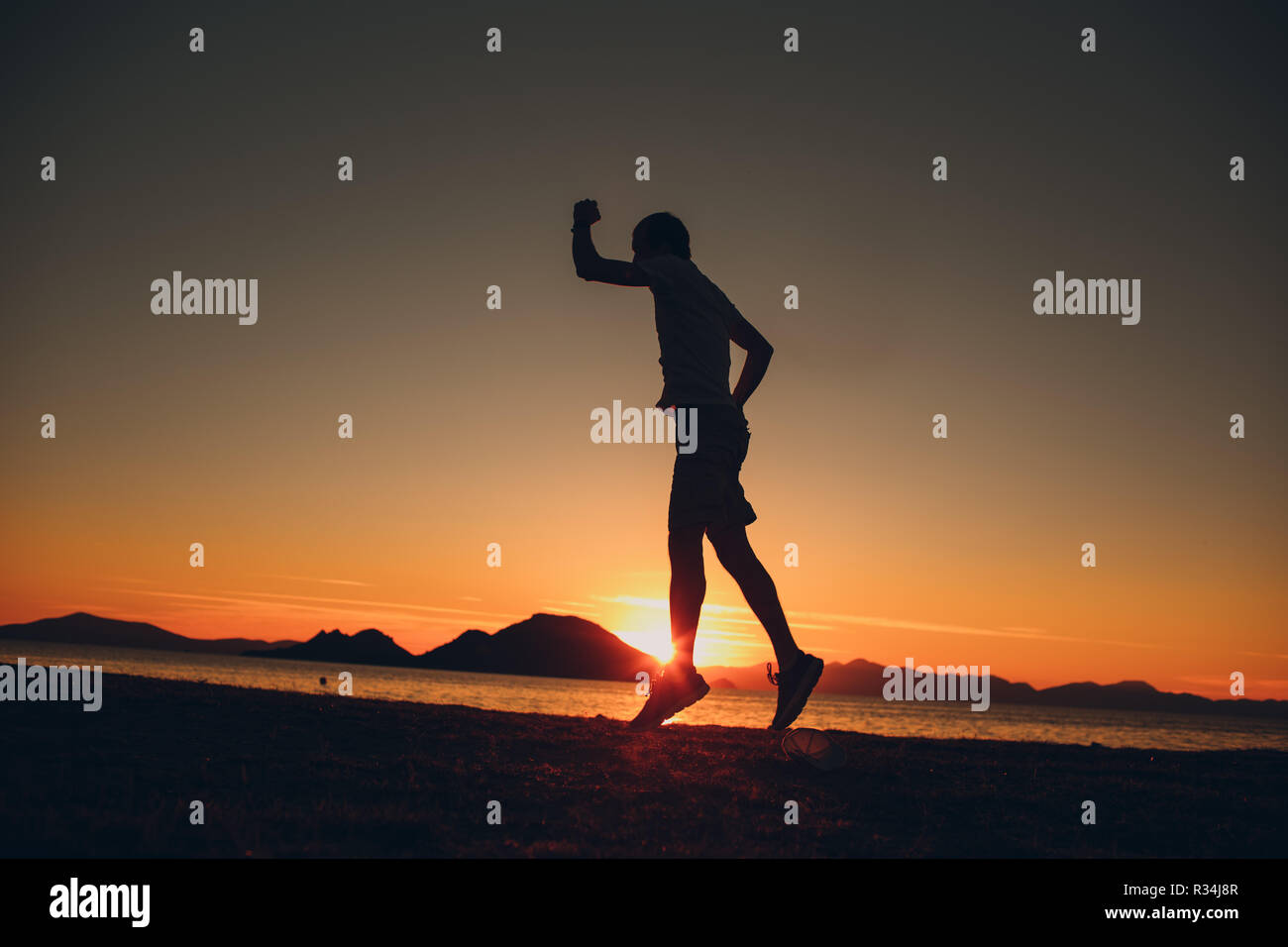 Young energetic happy man jumping on the seashore Stock Photo - Alamy