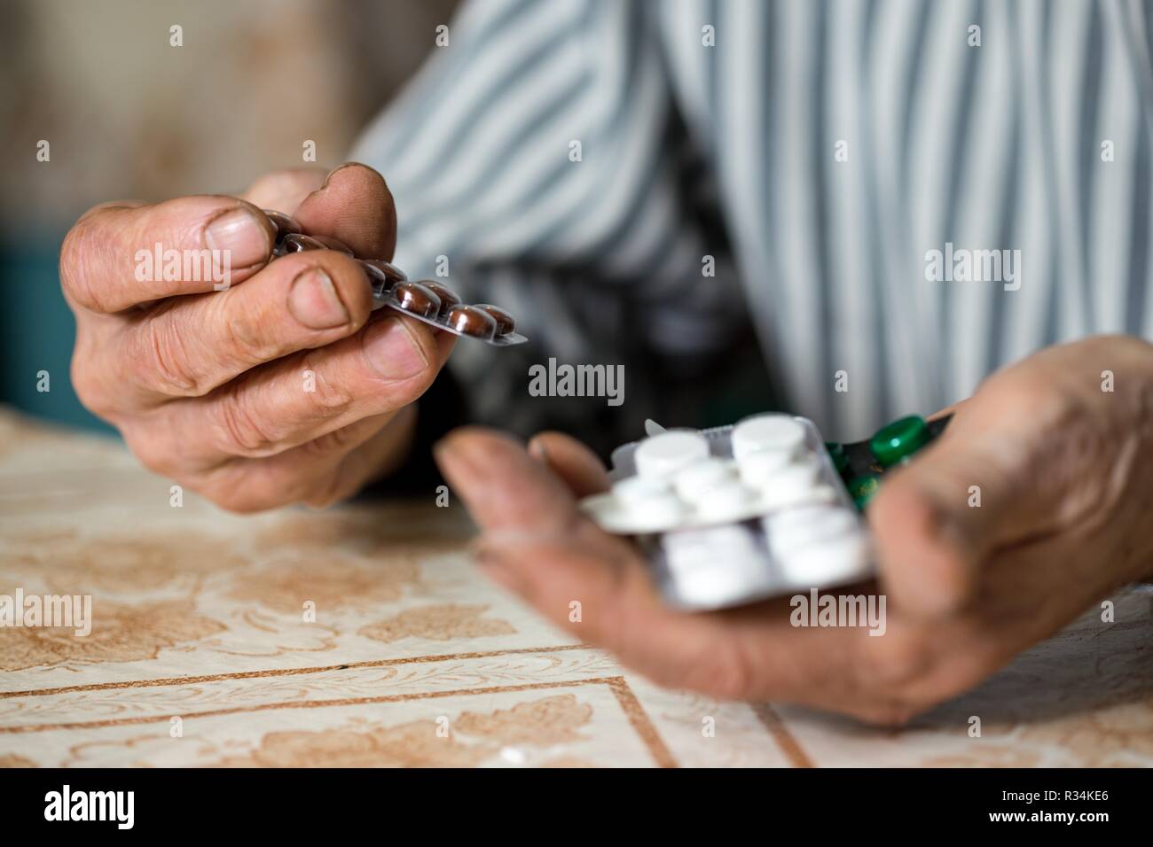senior man holds a pill in his hands Stock Photo - Alamy