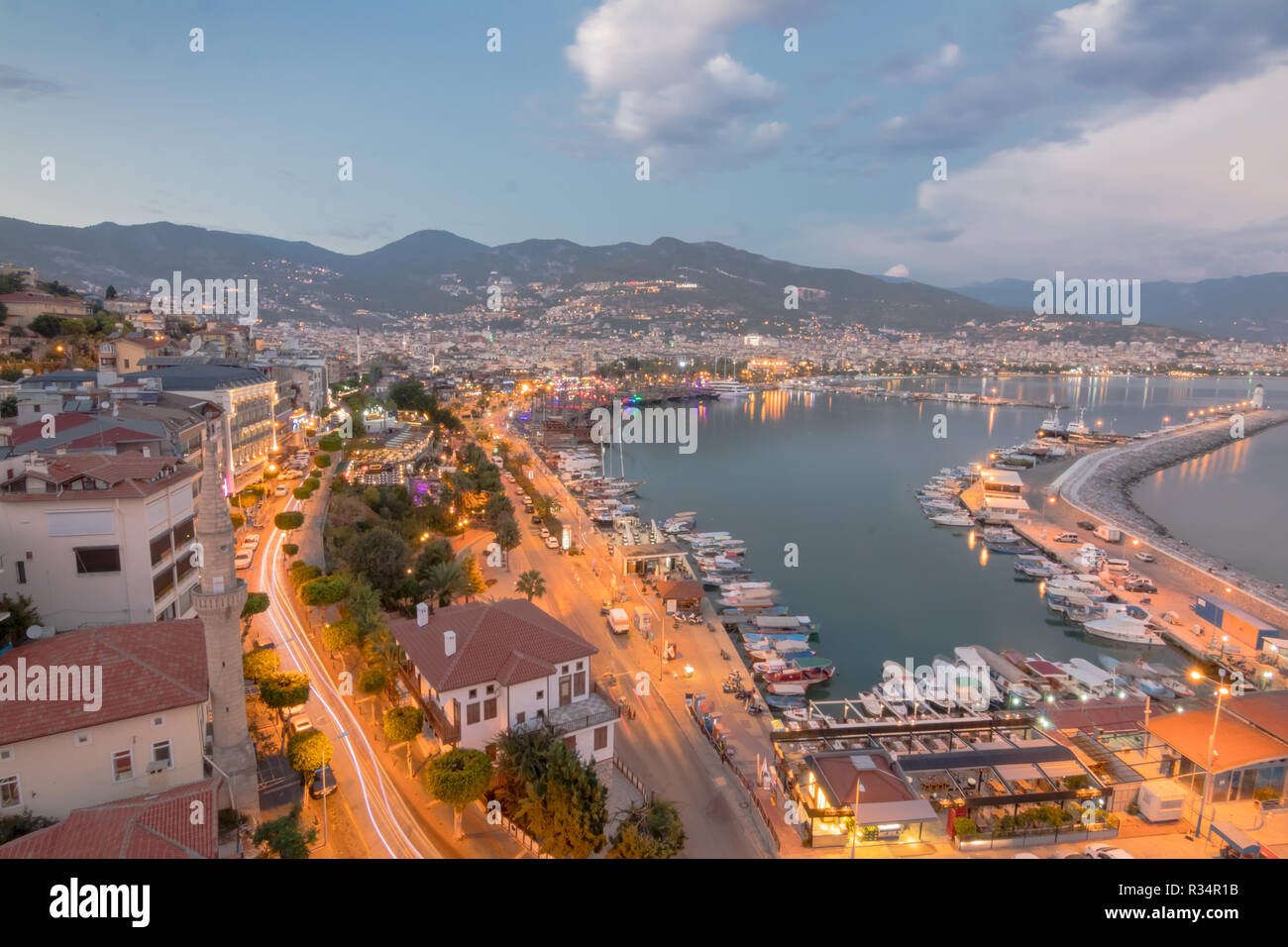 Alanya city harbor panorama in the evening with car traffic and ships ...