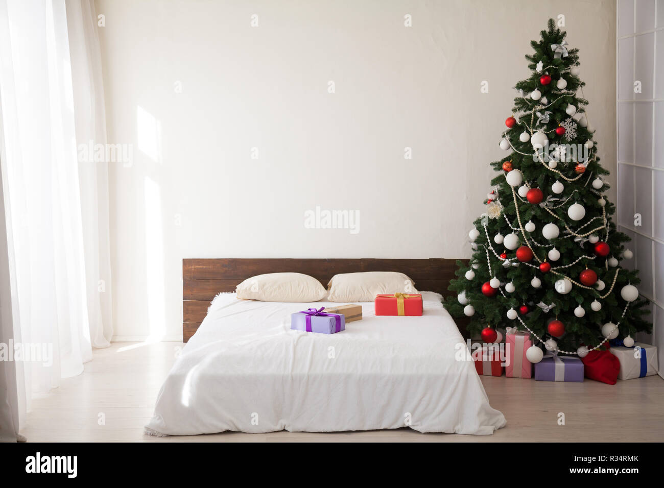 Interior bedroom with bed and Christmas tree new year holidays gifts ...
