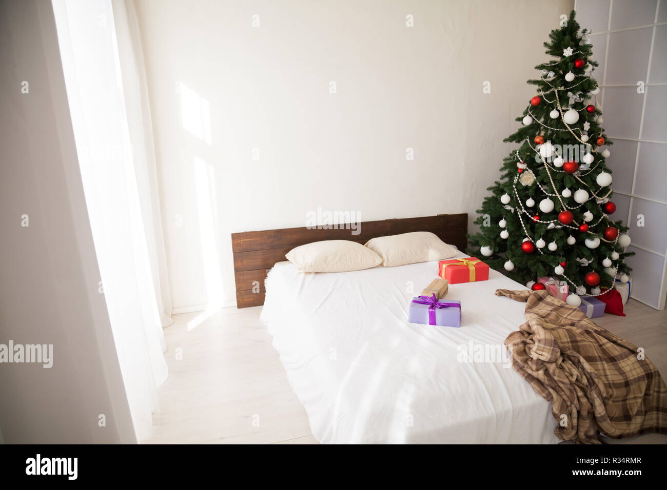 Interior bedroom with bed and Christmas tree new year holidays gifts ...