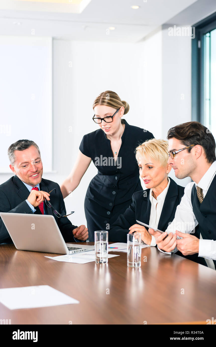 Business people looking at laptop Stock Photo - Alamy