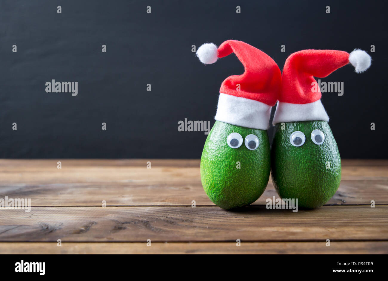 Christmas avocado couple. avocado in christmas hat Stock Photo - Alamy