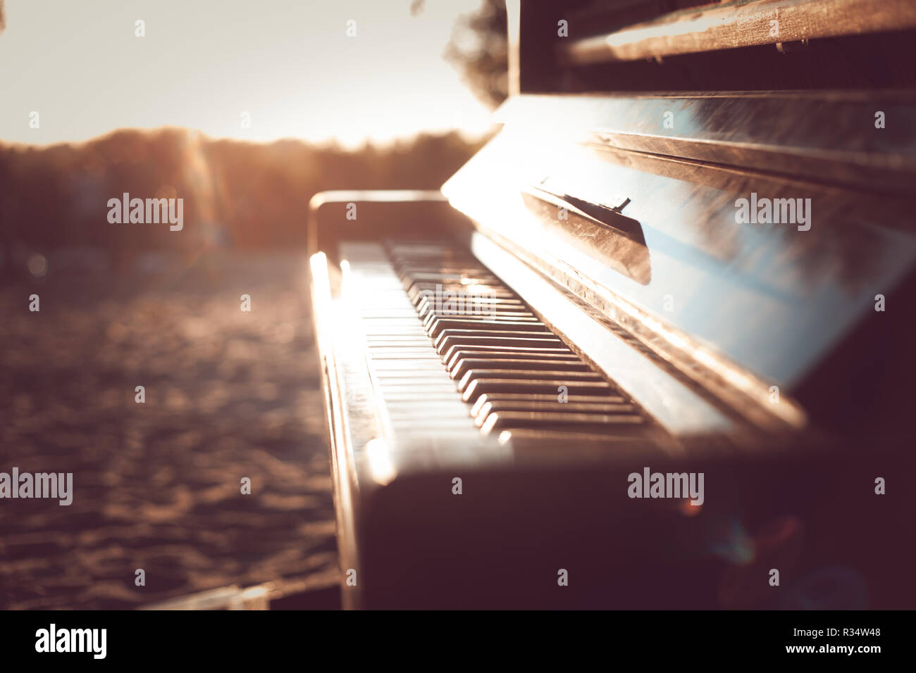 vintage piano standing on the beach on sunset background Stock Photo ...