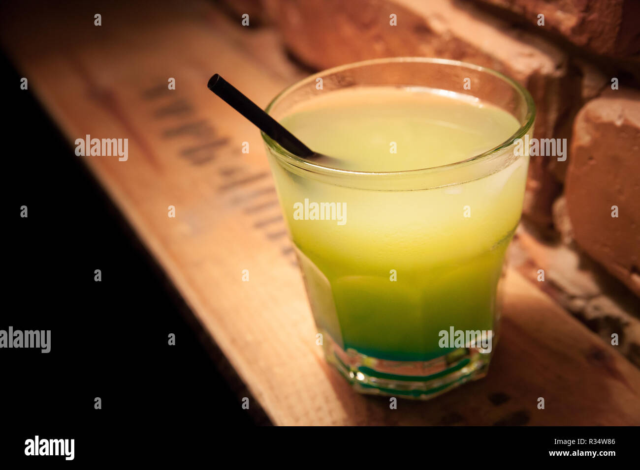 Green cocktail with a straw on the bar Stock Photo - Alamy
