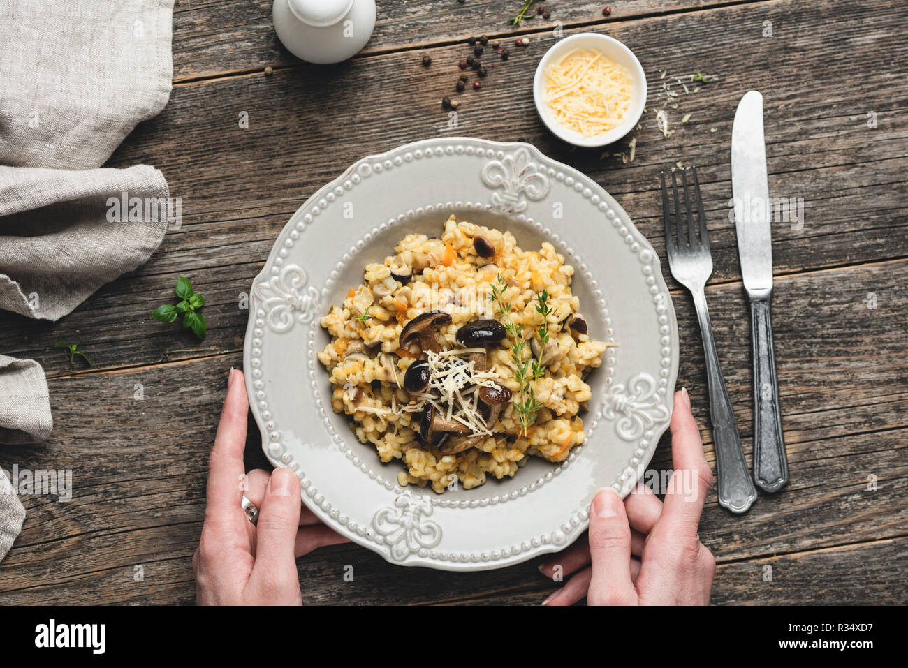 Barley mushrom risotto on plate over rustic wooden background with ...