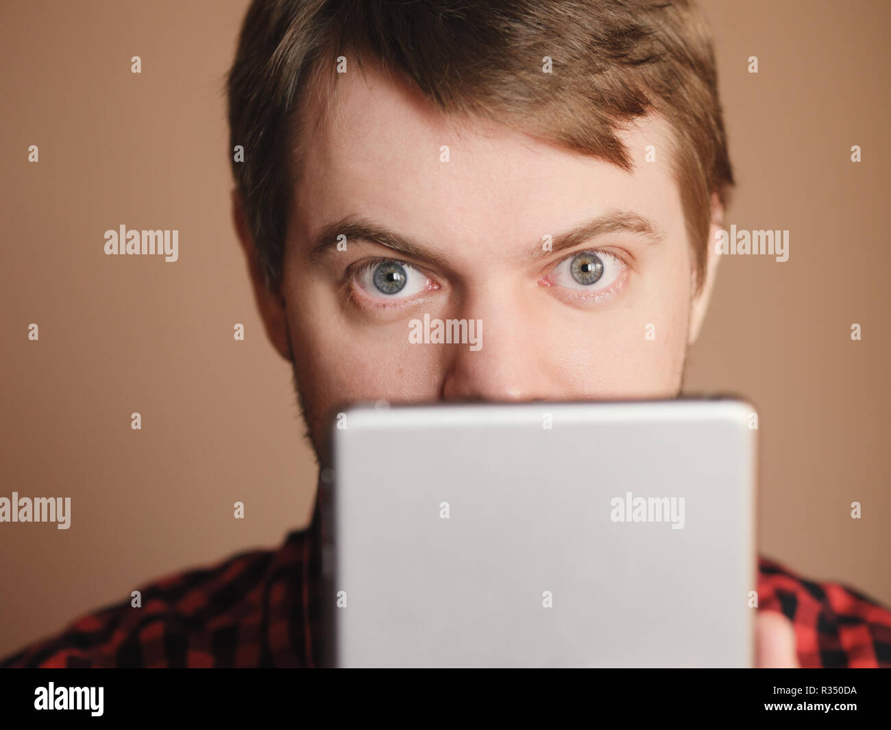 Young emotional man with pda looking down at camera Stock Photo - Alamy