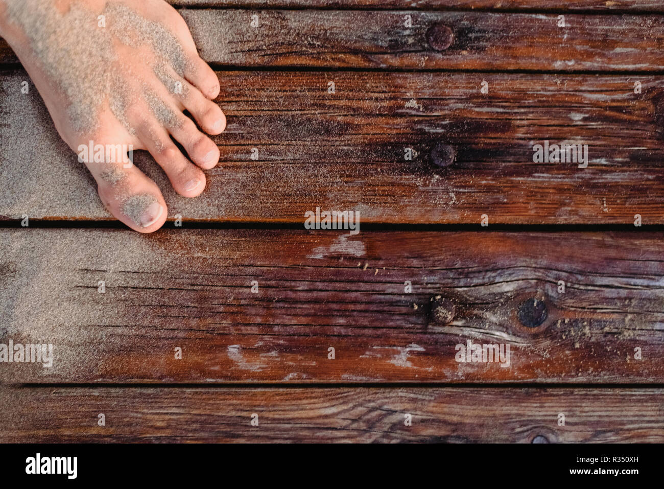 Foot stained with beach sand on some wooden boards in summer Stock ...