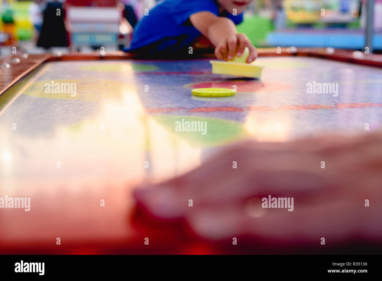 Hand holding a stick to hit disc in the table air hockey game Stock ...