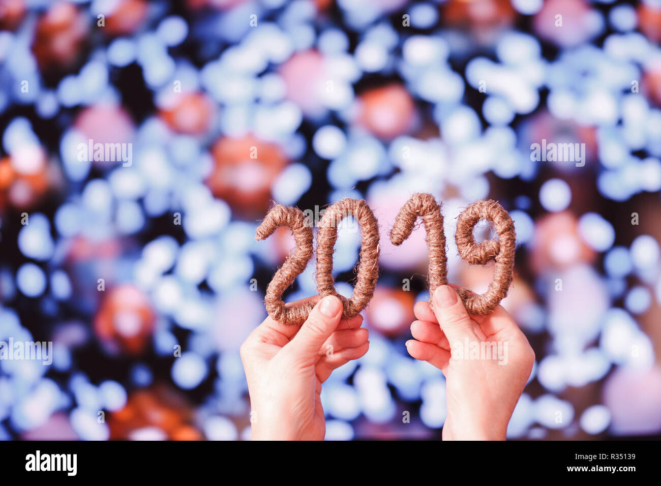 2019 numbers in hands and bokeh background. Christmas and happy new ...