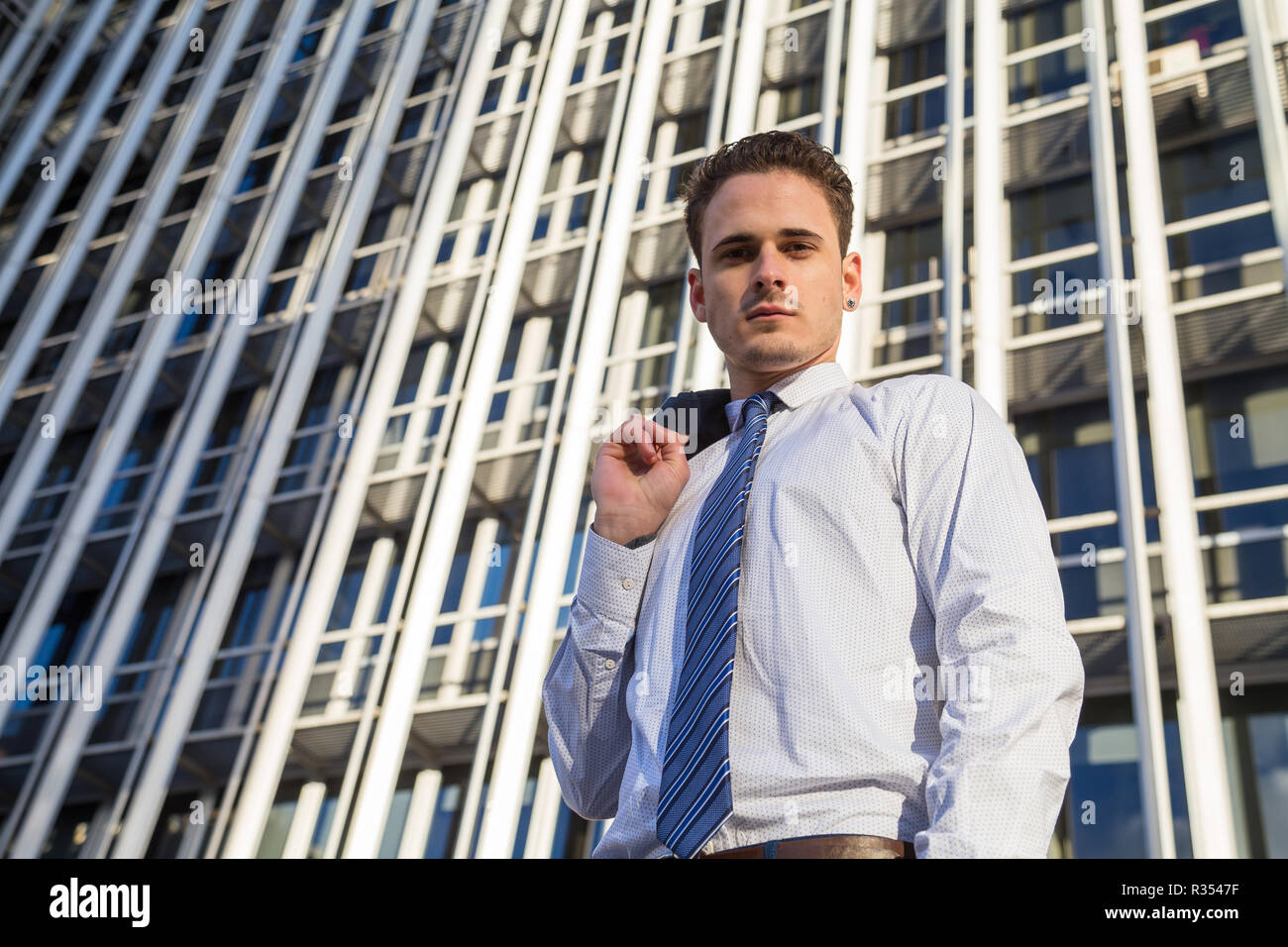 Businessman in classy suit holding his jacket on background of modern ...