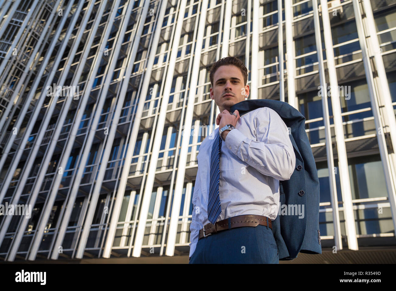 Businessman in classy suit holding his jacket on background of modern ...
