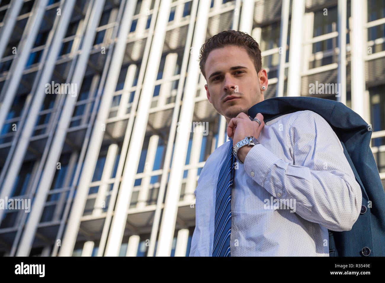 Businessman in classy suit holding his jacket on background of modern ...
