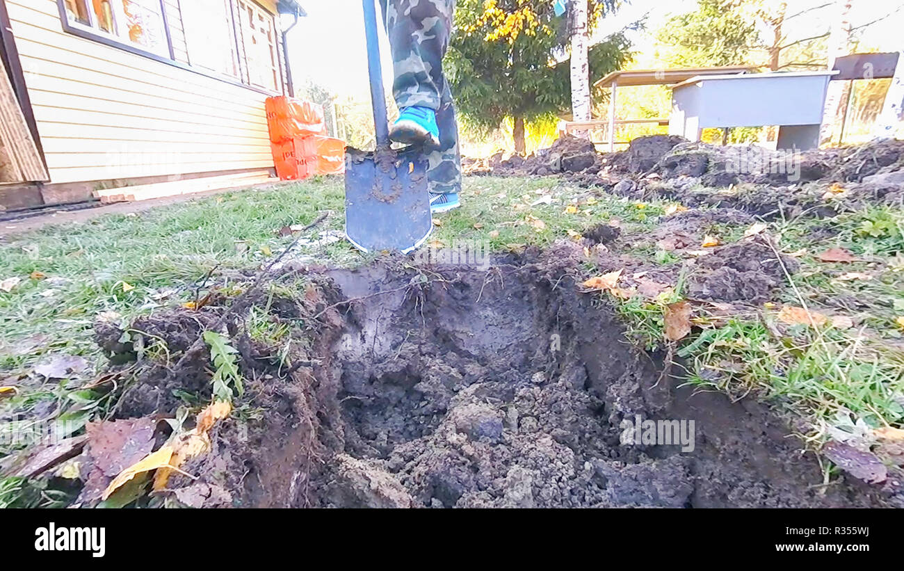 Digging clay in the ground with a shovel in the fall Stock Photo - Alamy