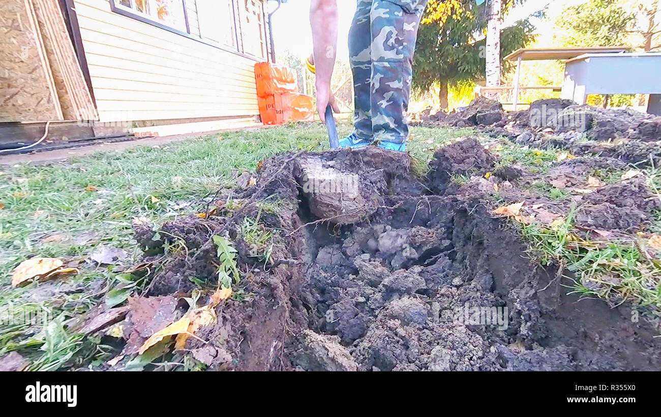 Digging clay in the ground with a shovel in the fall Stock Photo - Alamy