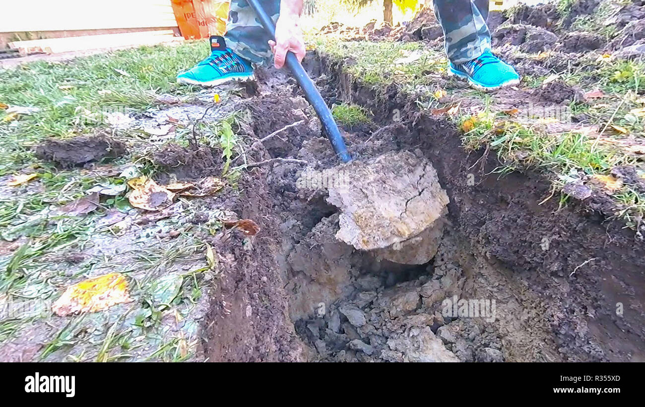 Digging clay in the ground with a shovel in the fall Stock Photo - Alamy