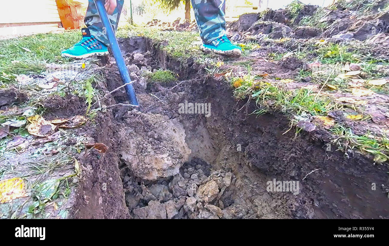 Man digging a ditch with a shovel in autumn Stock Photo - Alamy