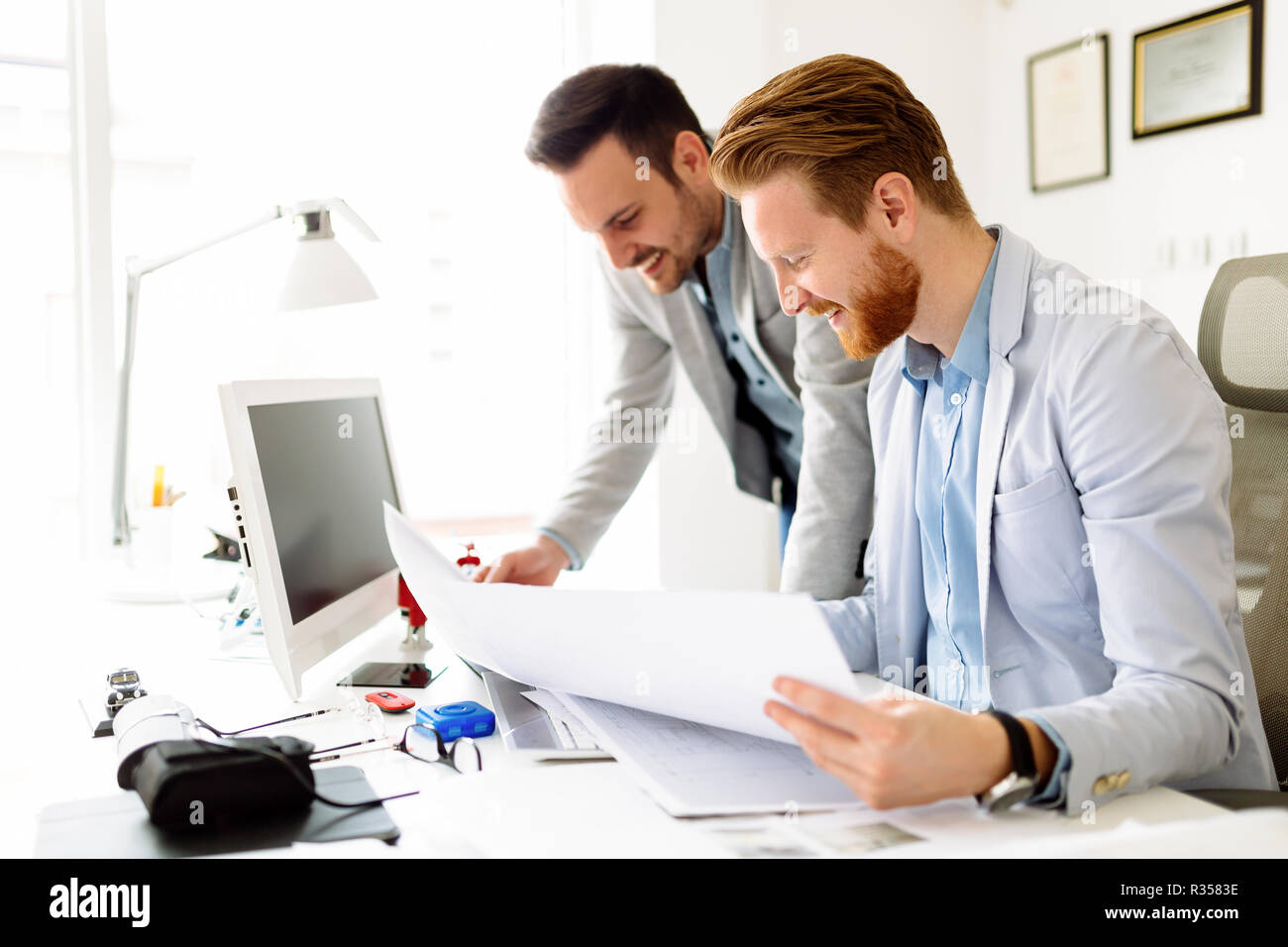 Coworkers working on project together in modern office Stock Photo - Alamy