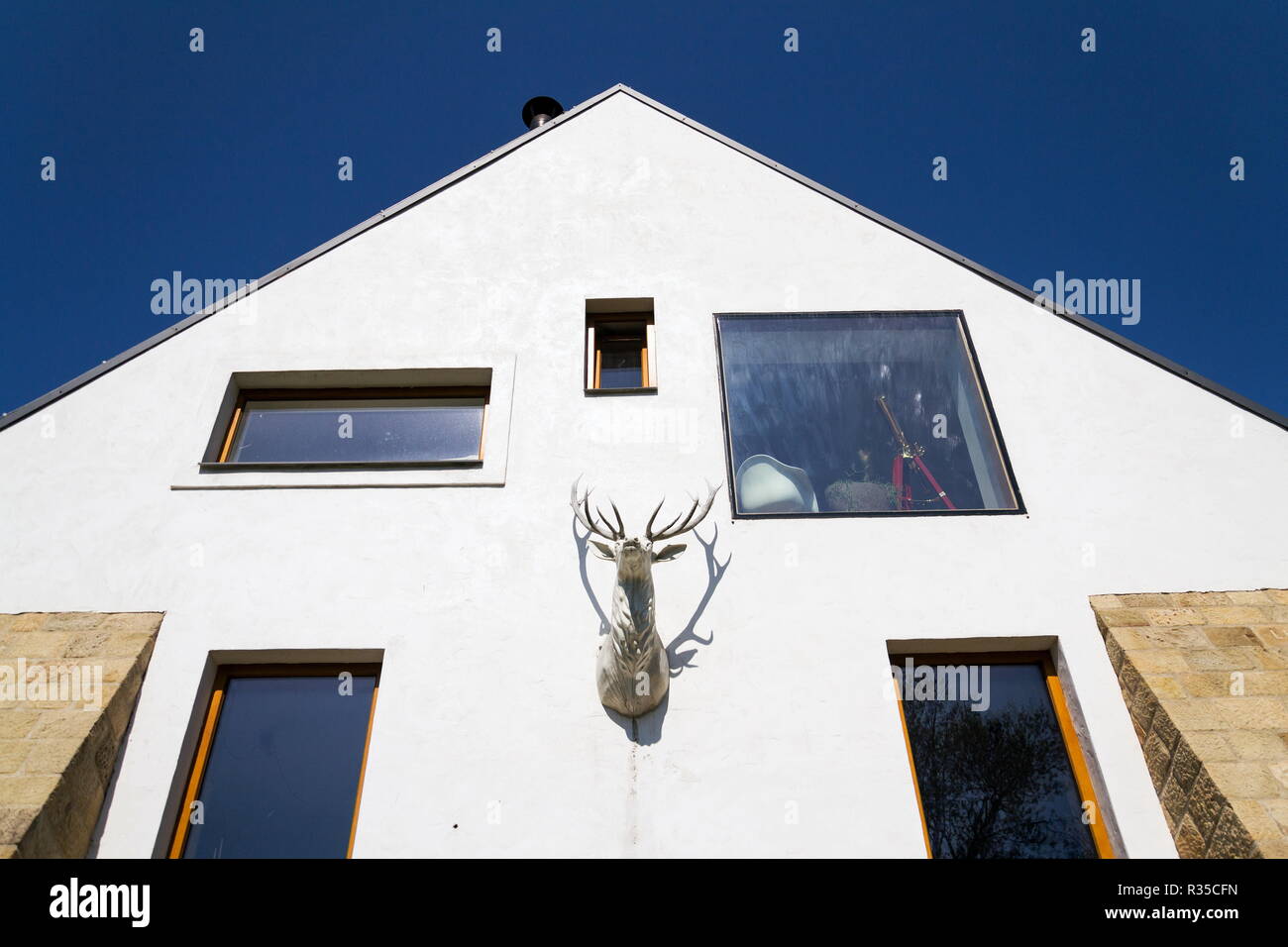 Deer head relief sculpture on facade of beautiful white village ...