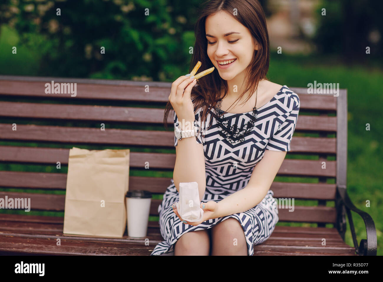 young model enjoying the break and eating fries Stock Photo - Alamy