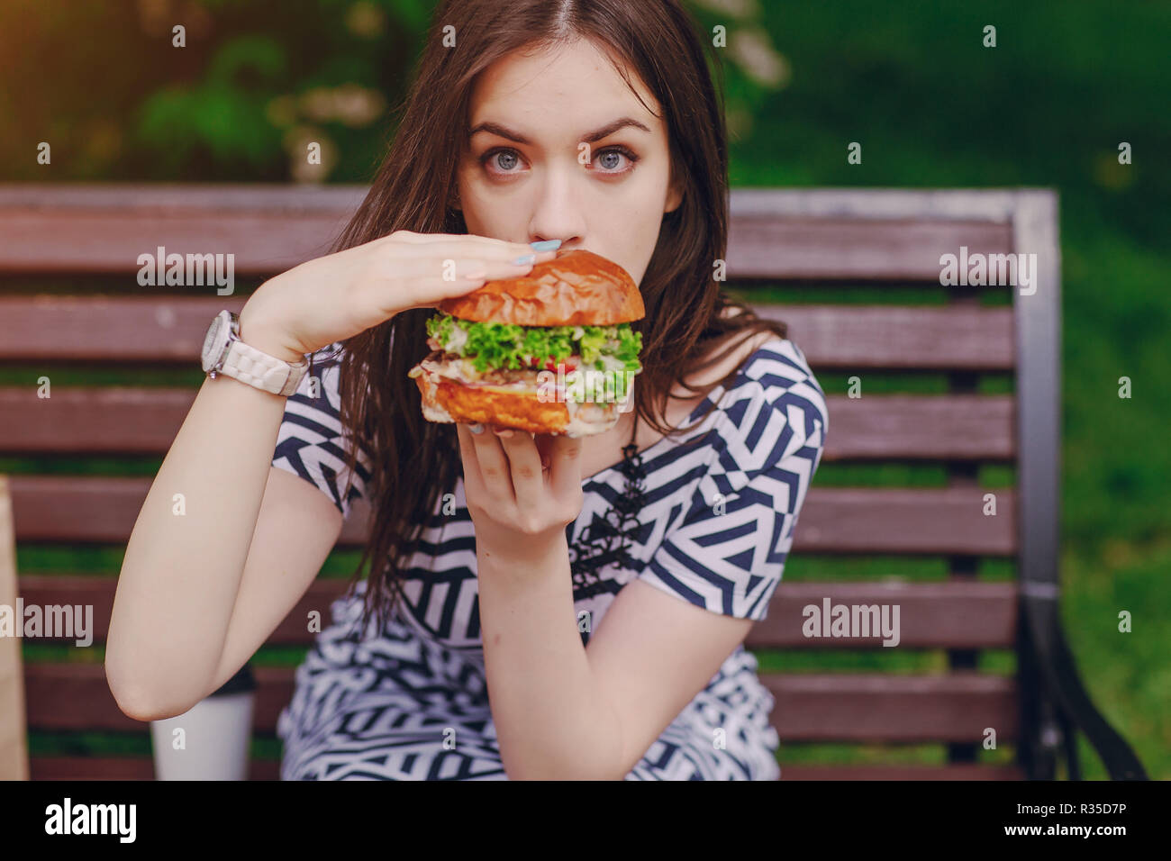 young model enjoying the break and eating a Burger Stock Photo - Alamy