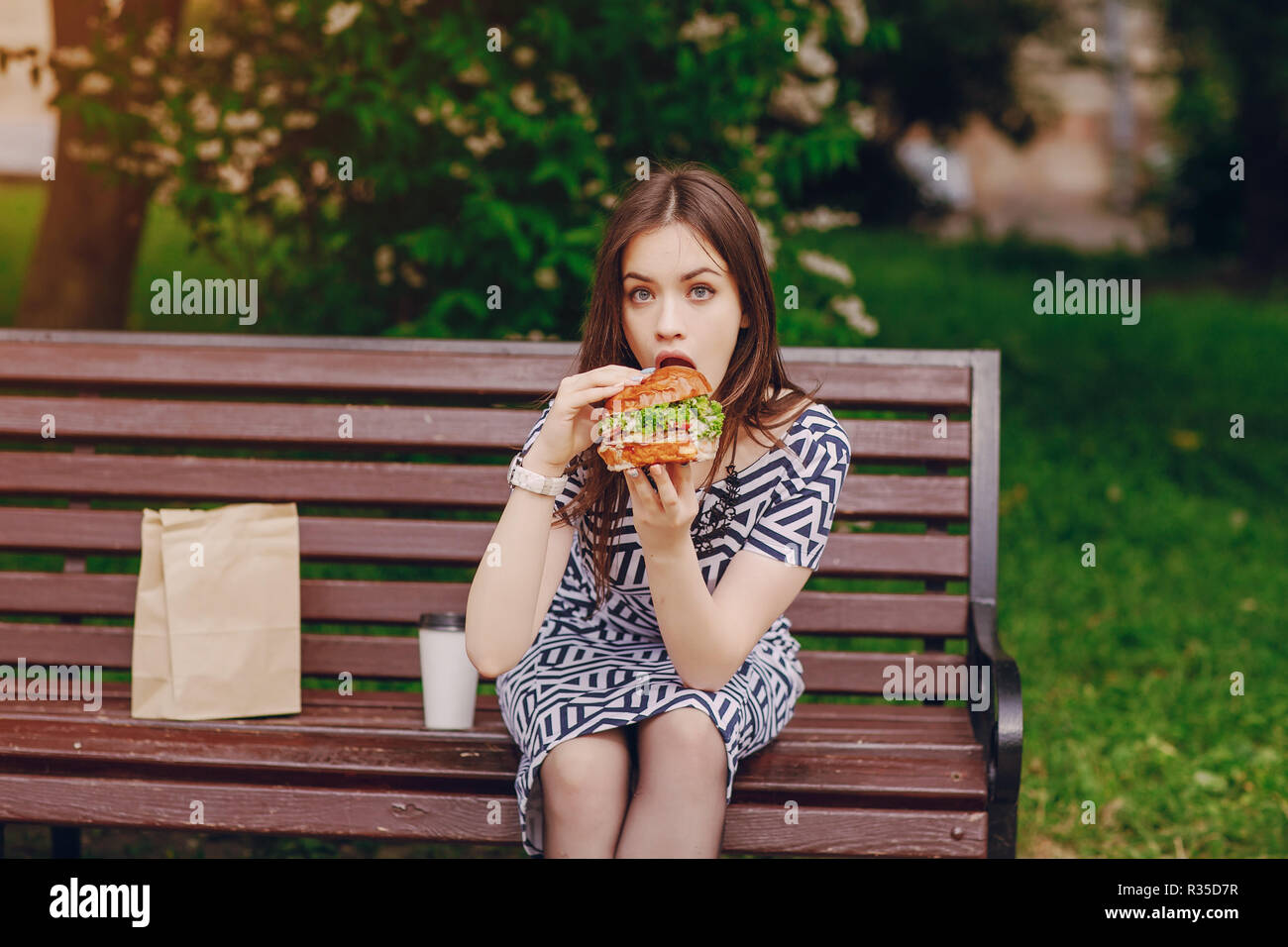 young model enjoying the break and eating a Burger Stock Photo - Alamy