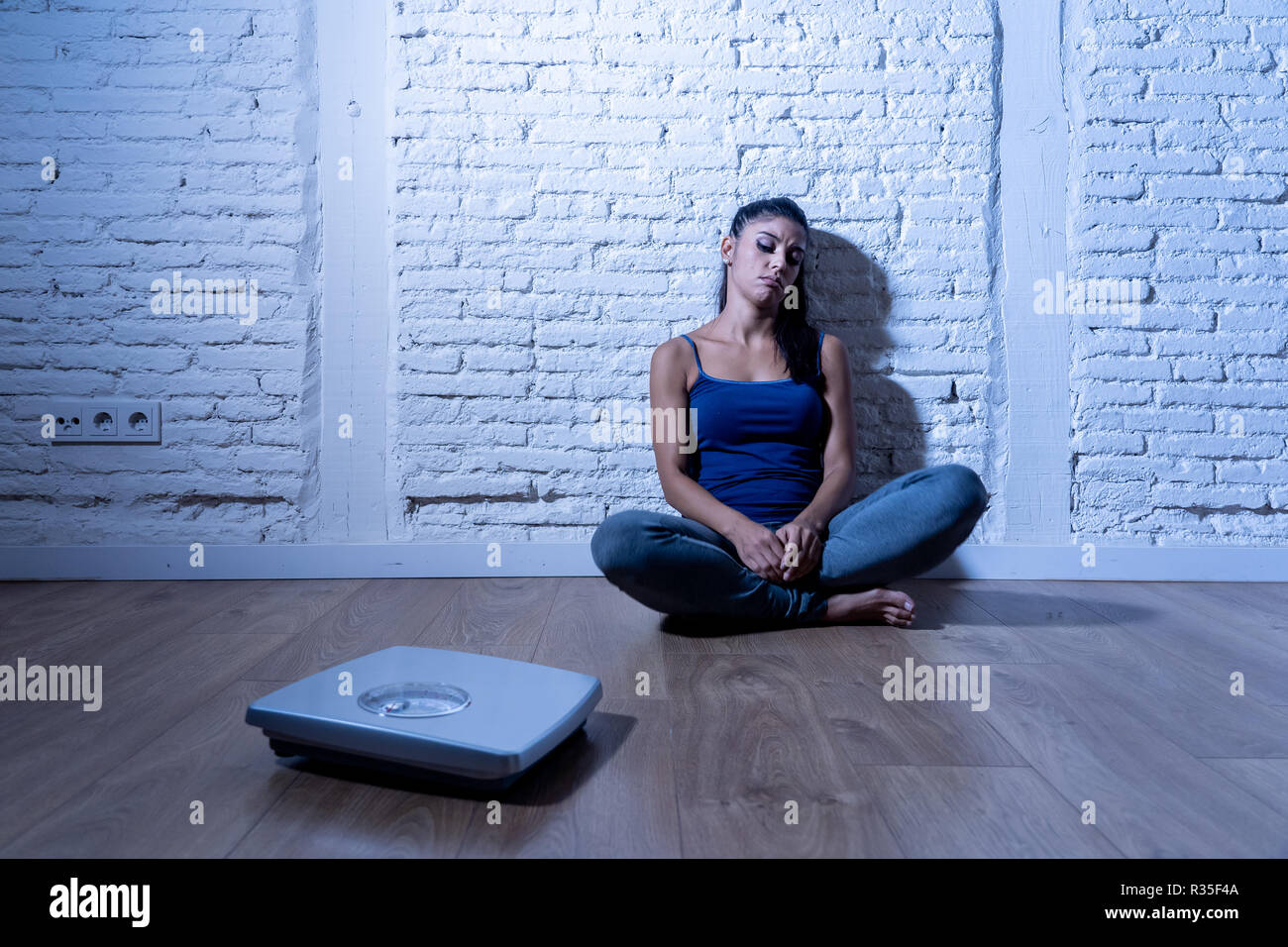 Young anorexic bulimic teenager woman sitting alone on ground looking ...
