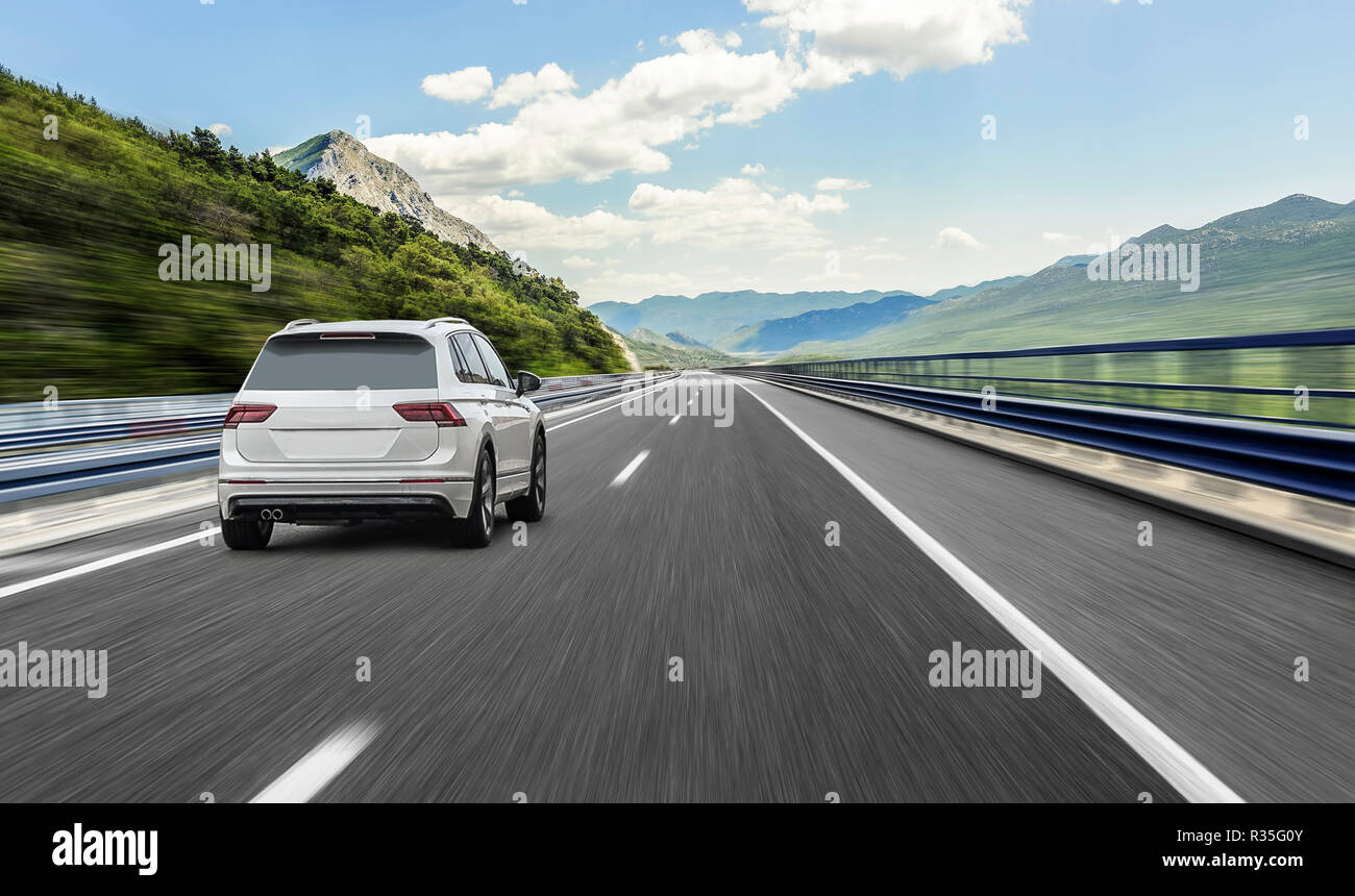 A white car rushing along a high-speed highway in the sun Stock Photo ...