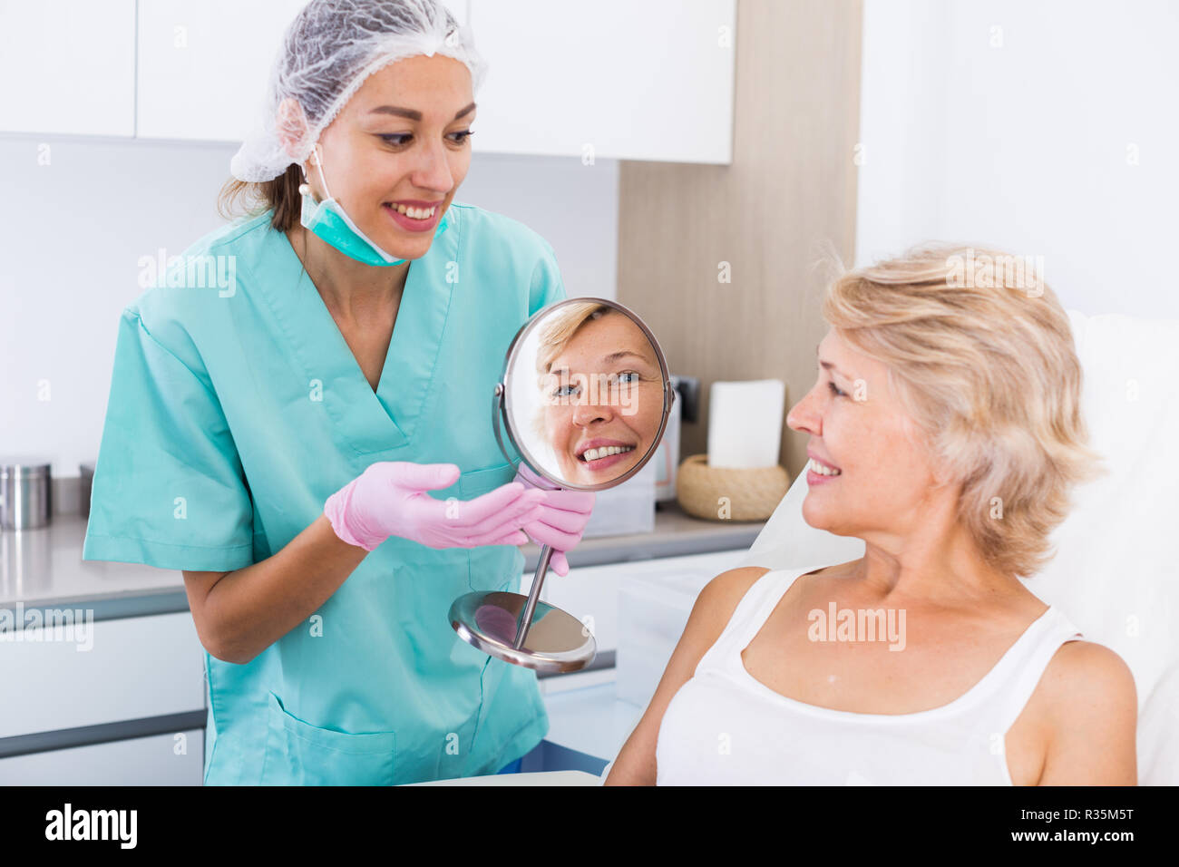 Smiling female patient satisfied after cosmetological procedure in ...