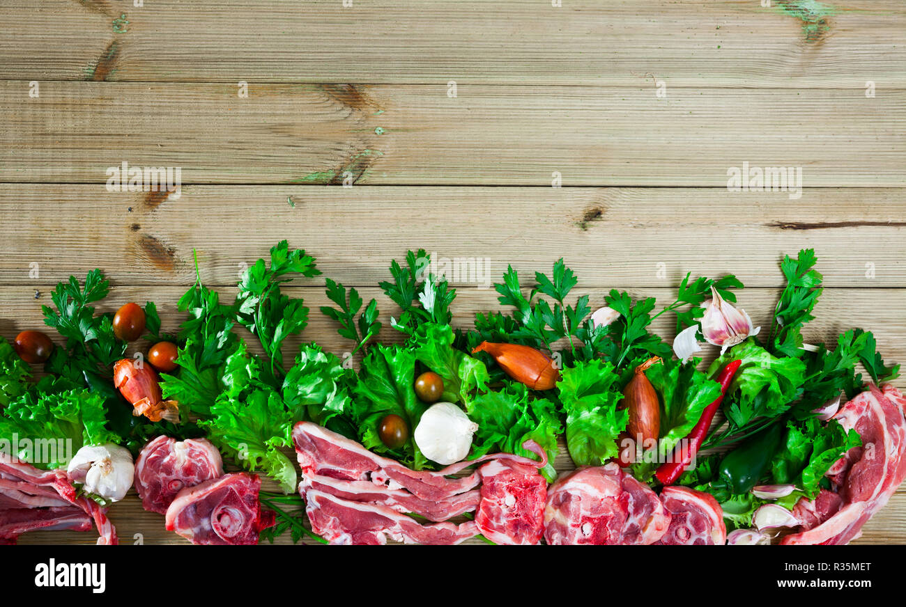 Raw mutton and vegetables assortment on natural wooden background ...
