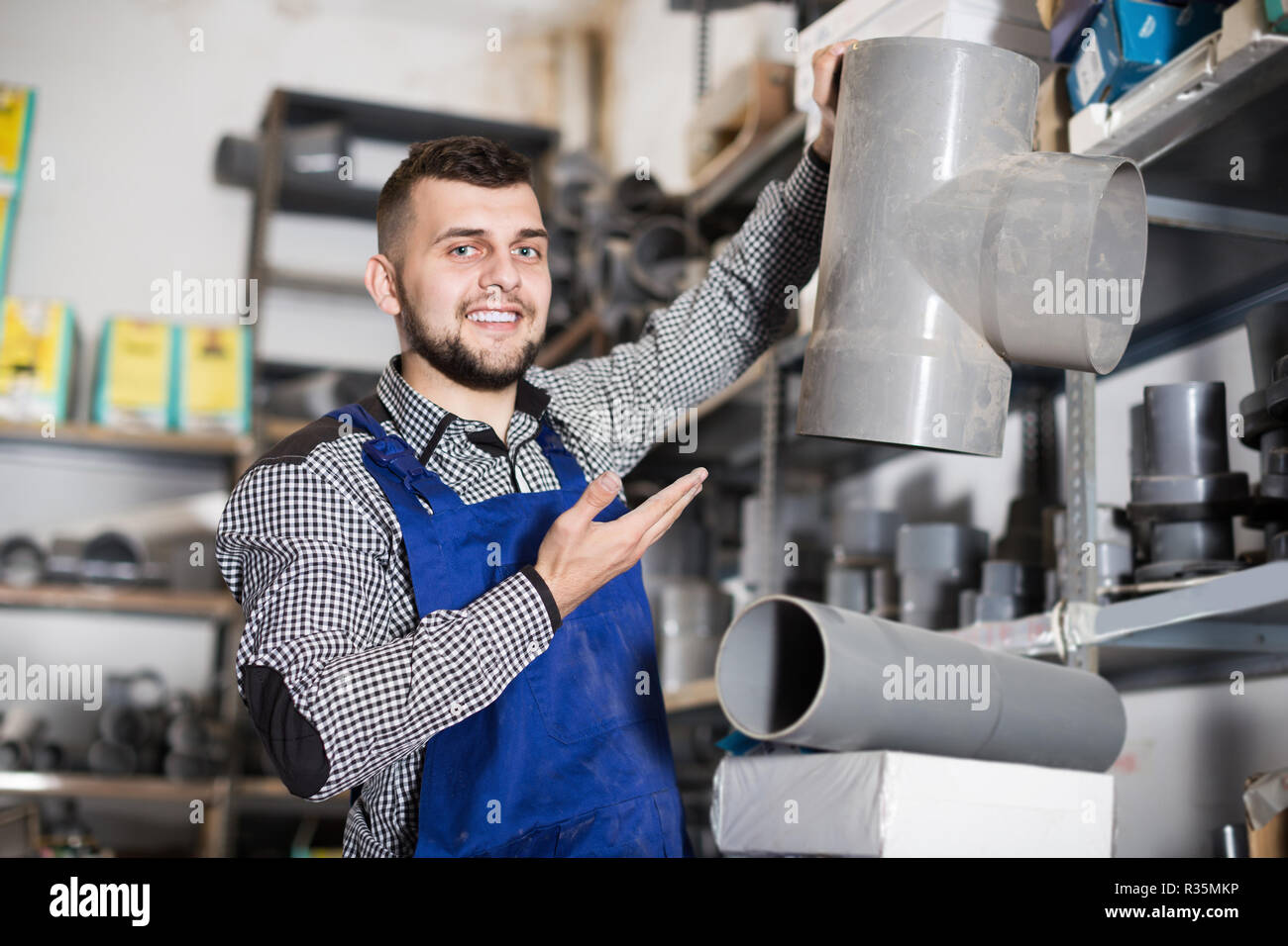 Young male worker examining sanitary drain pipes in workshop Stock ...
