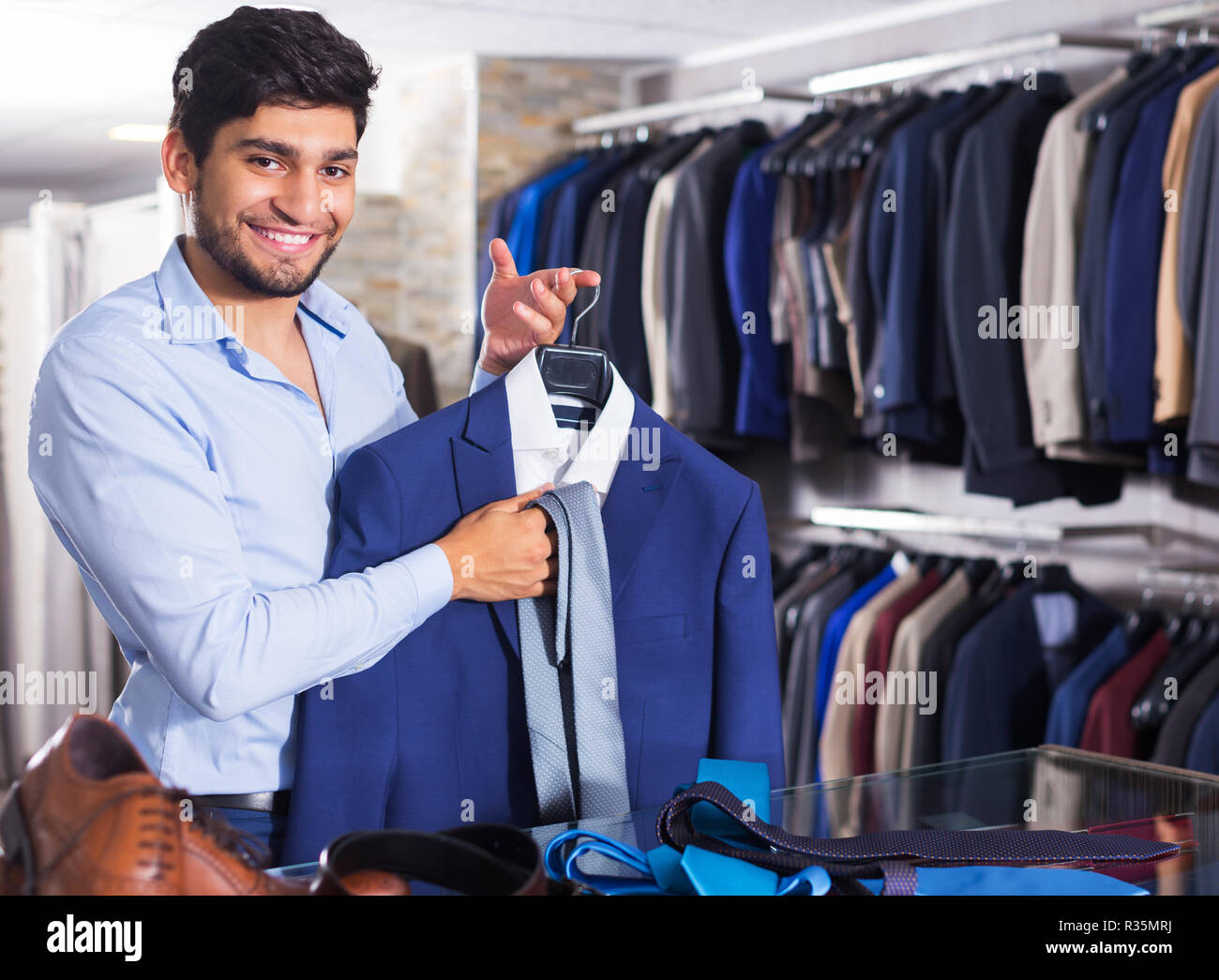 Male customer demonstrating his choice of suit in store Stock Photo - Alamy