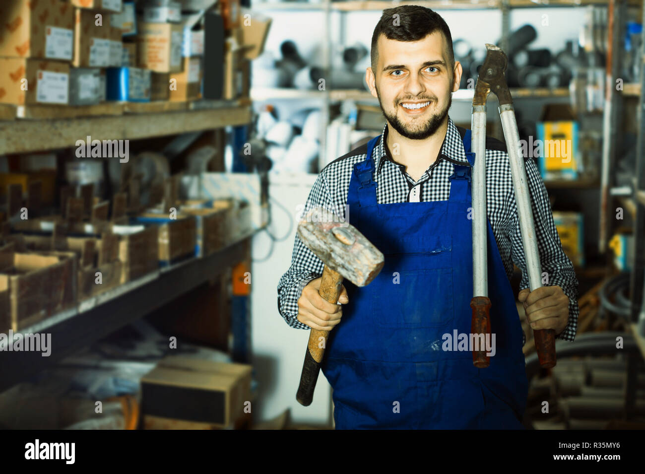 Smiling man worker showing constructing instruments at workshop Stock ...