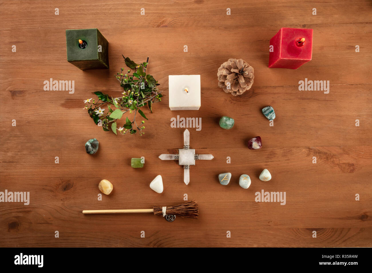 A Wicca altar with candles, crystal stones, and runes, with a broom ...