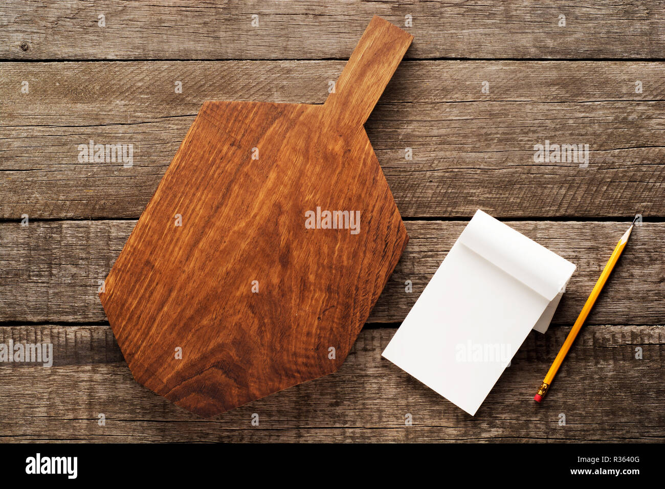 Notepad and chopping board with pencil on wooden table , recipes food ...