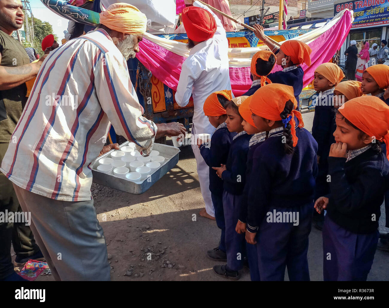 A Sikh devotee seen offering cold drinks to school children during the Nagar Keertan (Holy ...