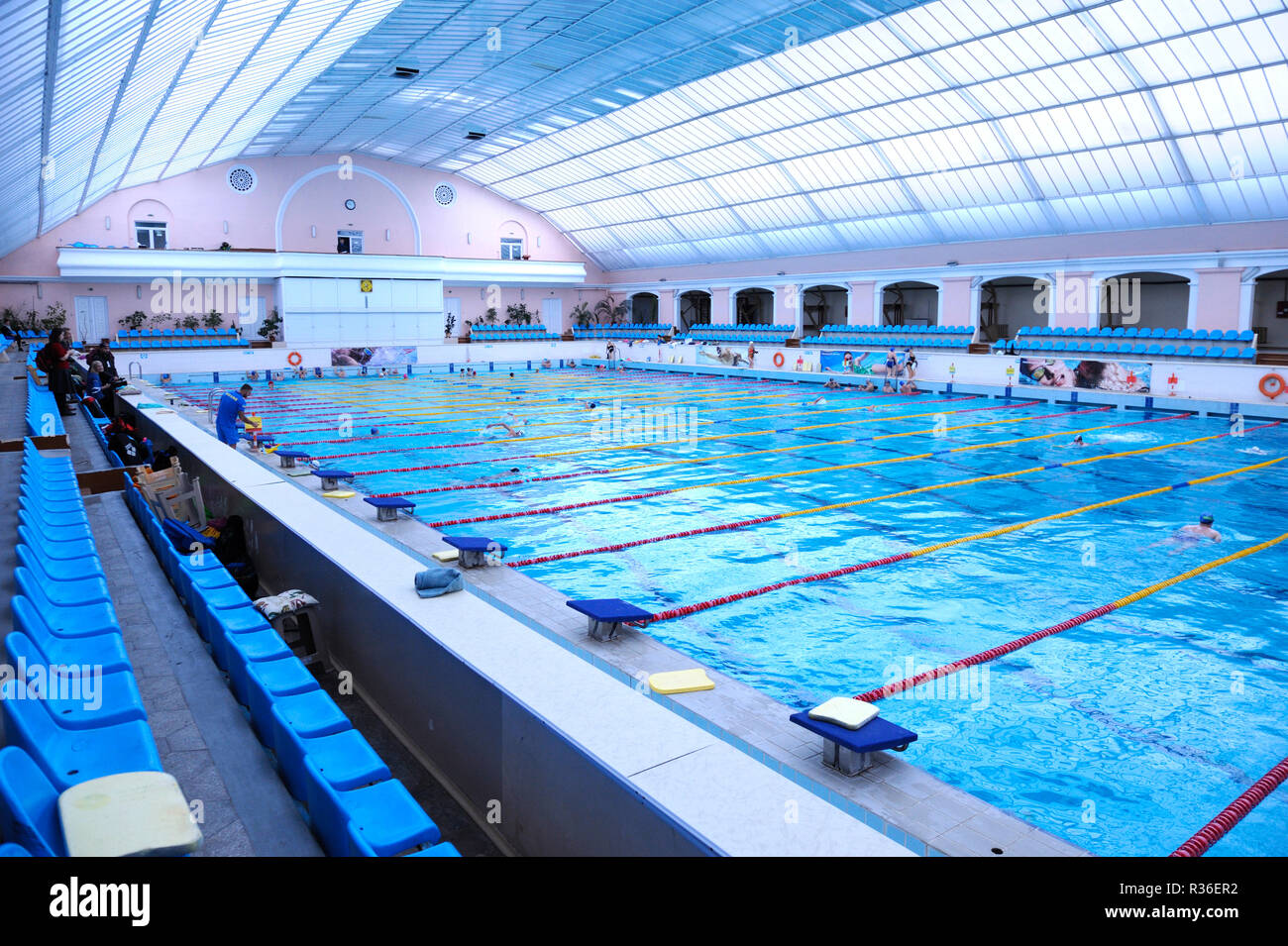 View of indoor swimming pool with people training. Pool of the Army ...