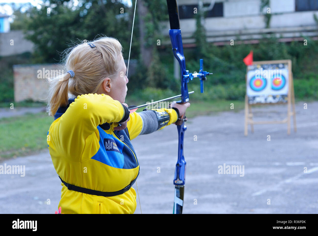 Training. Female archer aiming at a mark on an archery shooting range ...