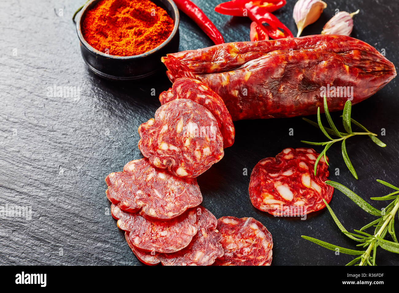 chorizo sausage cut in slices on a black slate plate with smoked ...