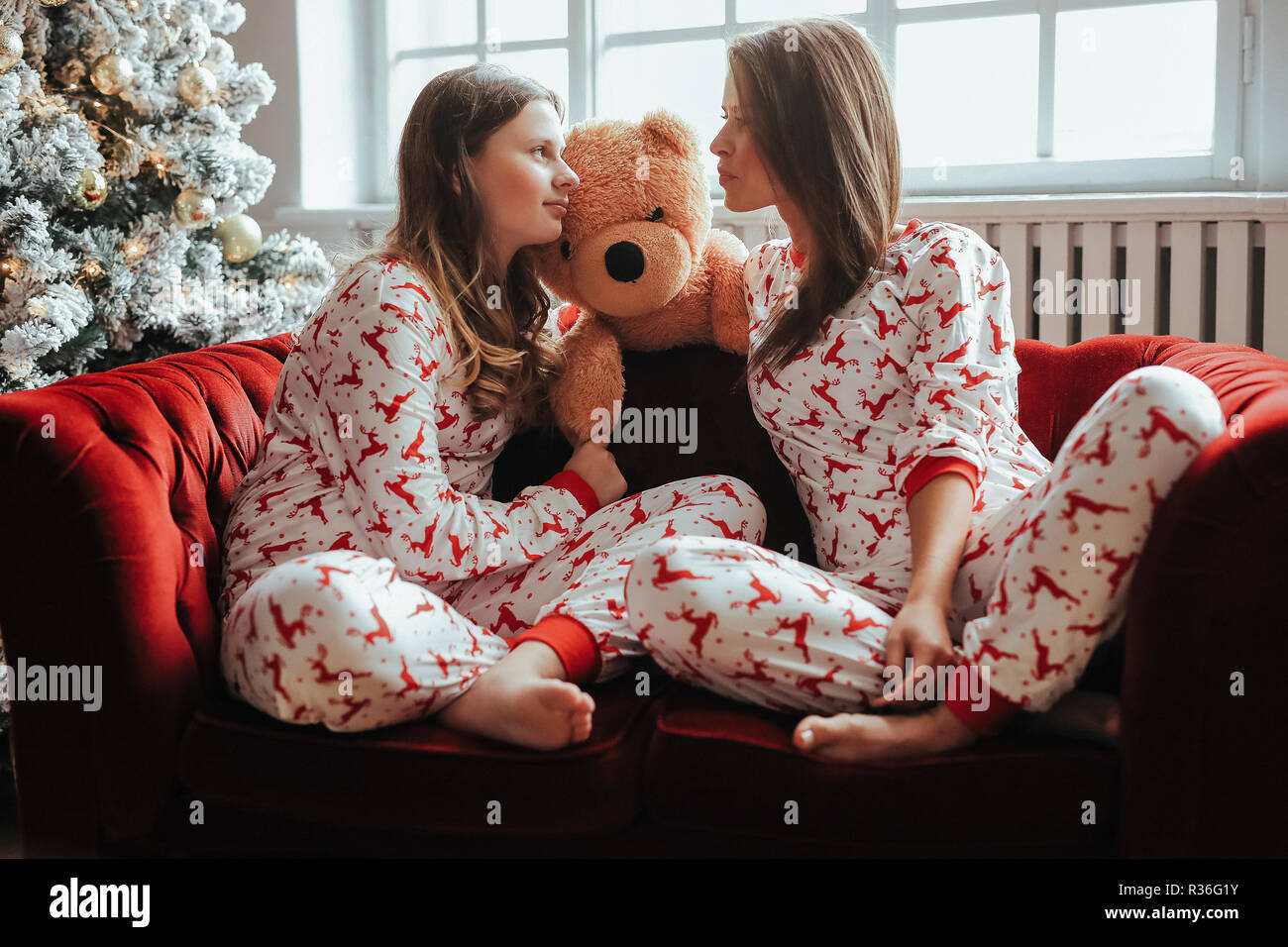 Young mother and her daughter in festive pajamas during christmas Stock ...