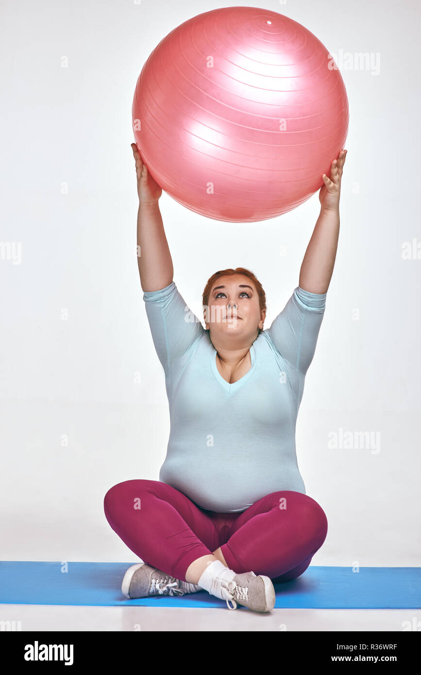Funny red haired, chubby woman is holding a ball Stock Photo - Alamy
