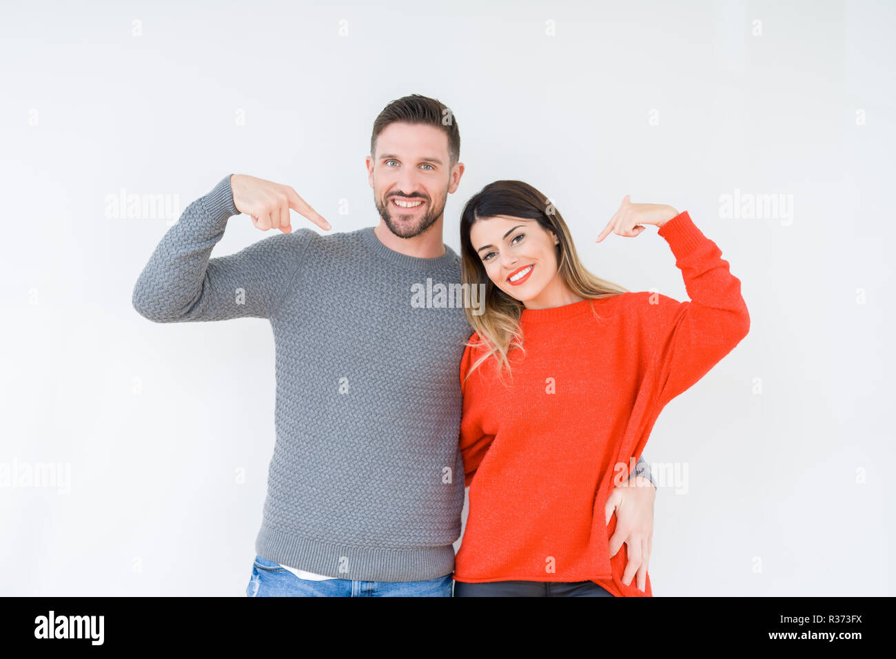 Young beautiful couple togheter over isolated background looking ...