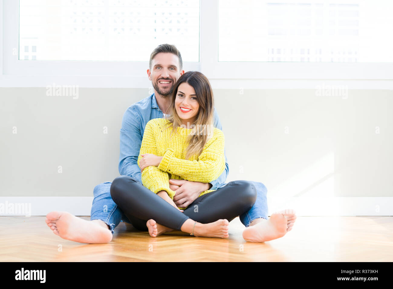 Beautiful young couple in love, kissing and hugging each other sitting ...