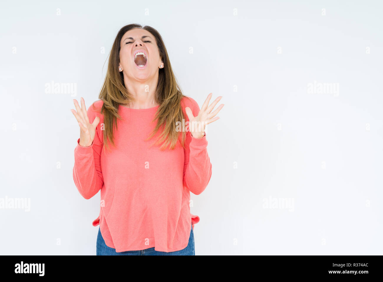 Beautiful middle age woman over isolated background crazy and mad ...