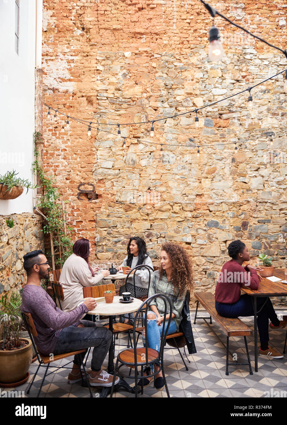 Young people talking over coffee in a cafe courtyard Stock Photo - Alamy