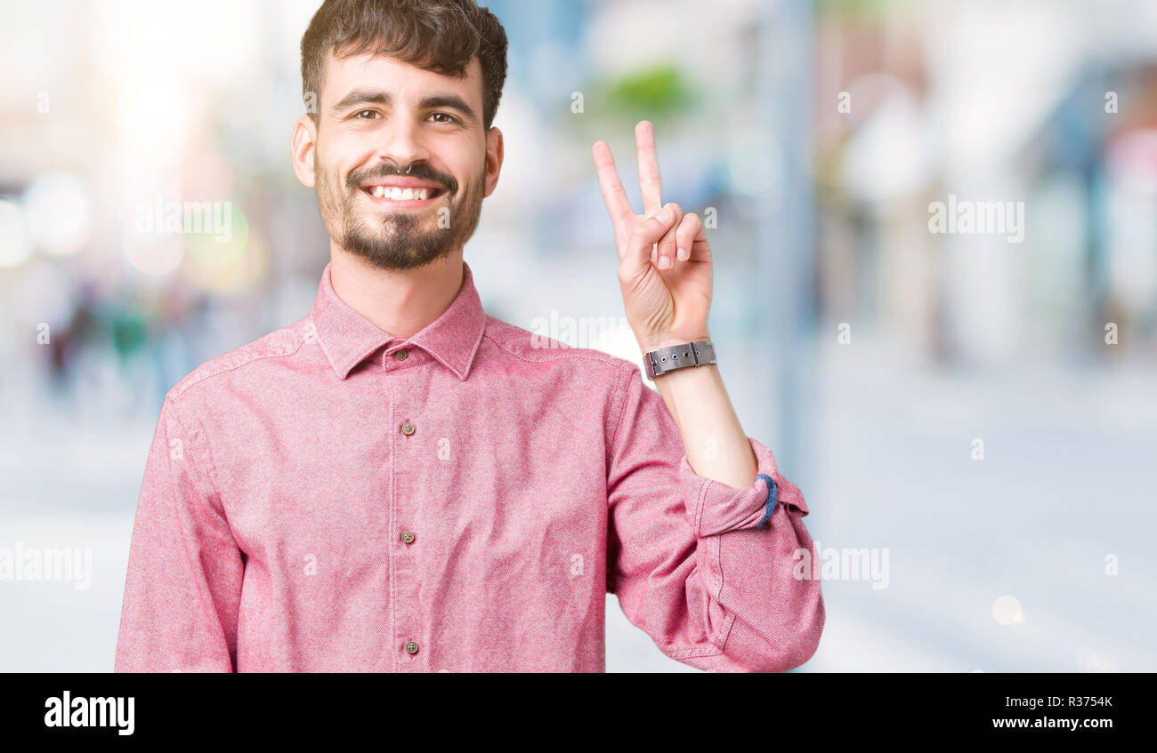 Young handsome man wearing pink shirt over isolated background showing ...