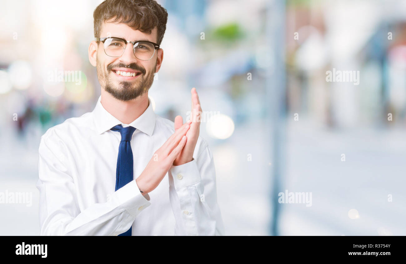 Young handsome business man wearing glasses over isolated background ...