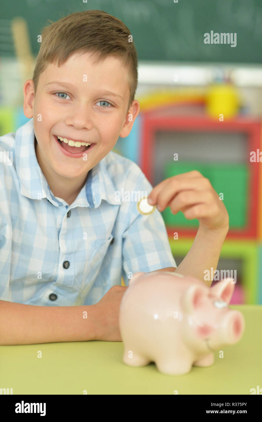 Portrait of a boy putting a coin Stock Photo - Alamy
